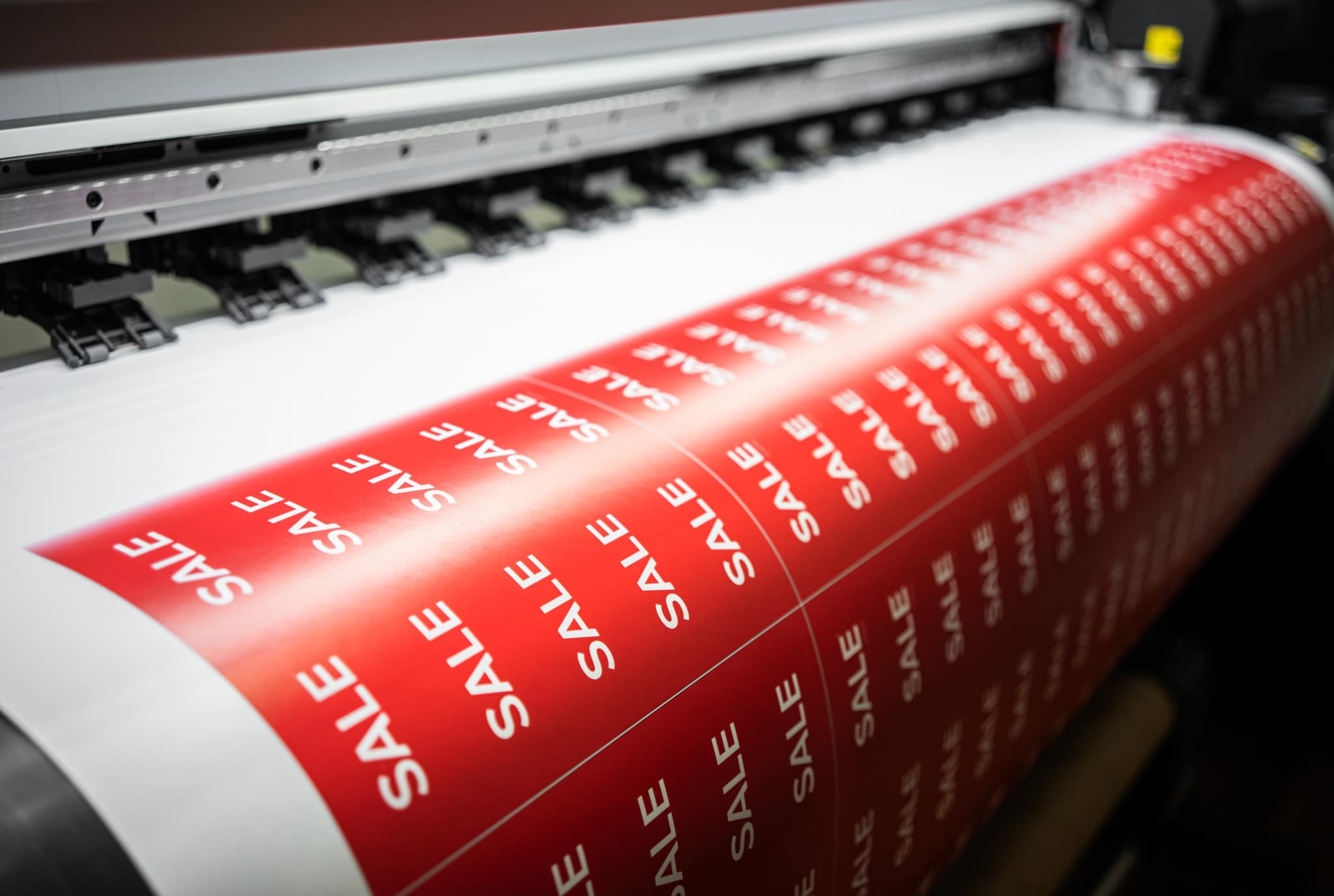 Printing stickers with white lettering for sale on a printing press ...